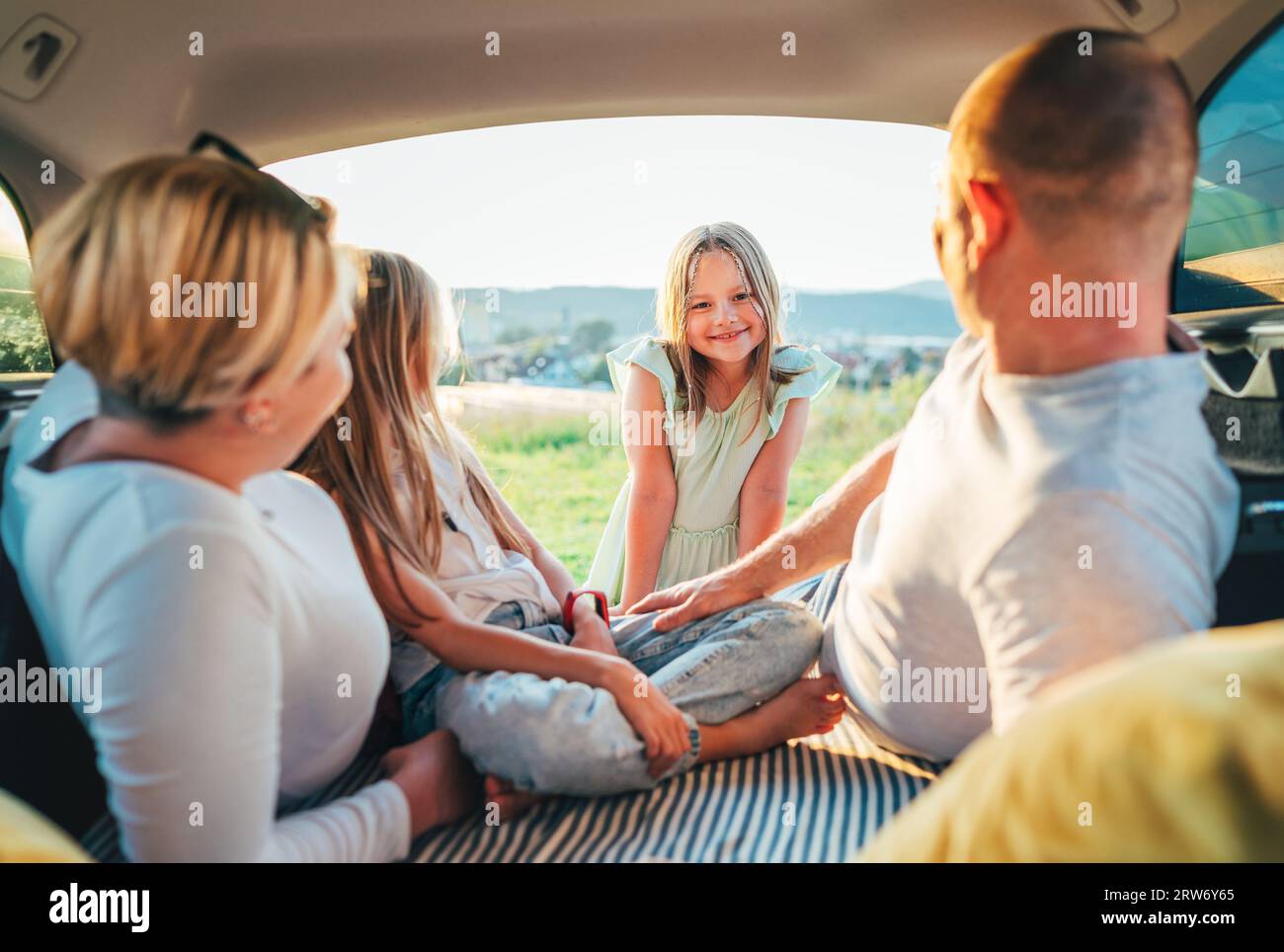 Portrait of happy smiling little girl gazing at camera. Happy young couple with two daughters ...