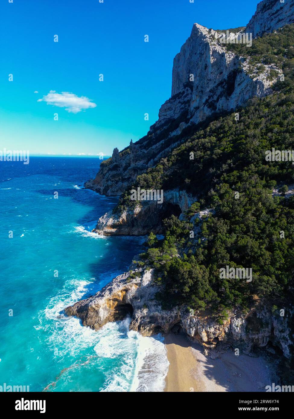 A stunning beach with a majestic cliff situated along the shoreline of ...