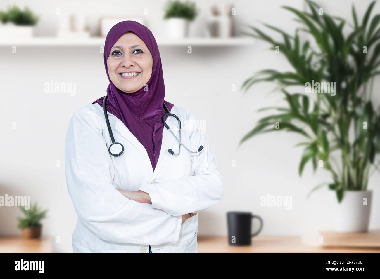 Portrait of Arabic muslim female doctor wearing hijab standing cross ...