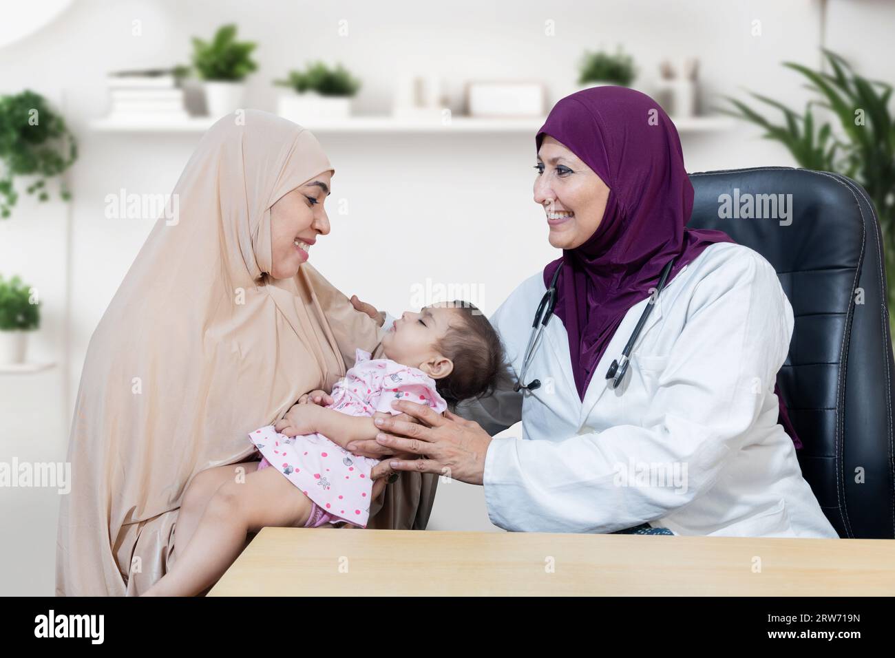Happy Young muslim mother wearing with her cute little baby visiting general pediatrician in ...