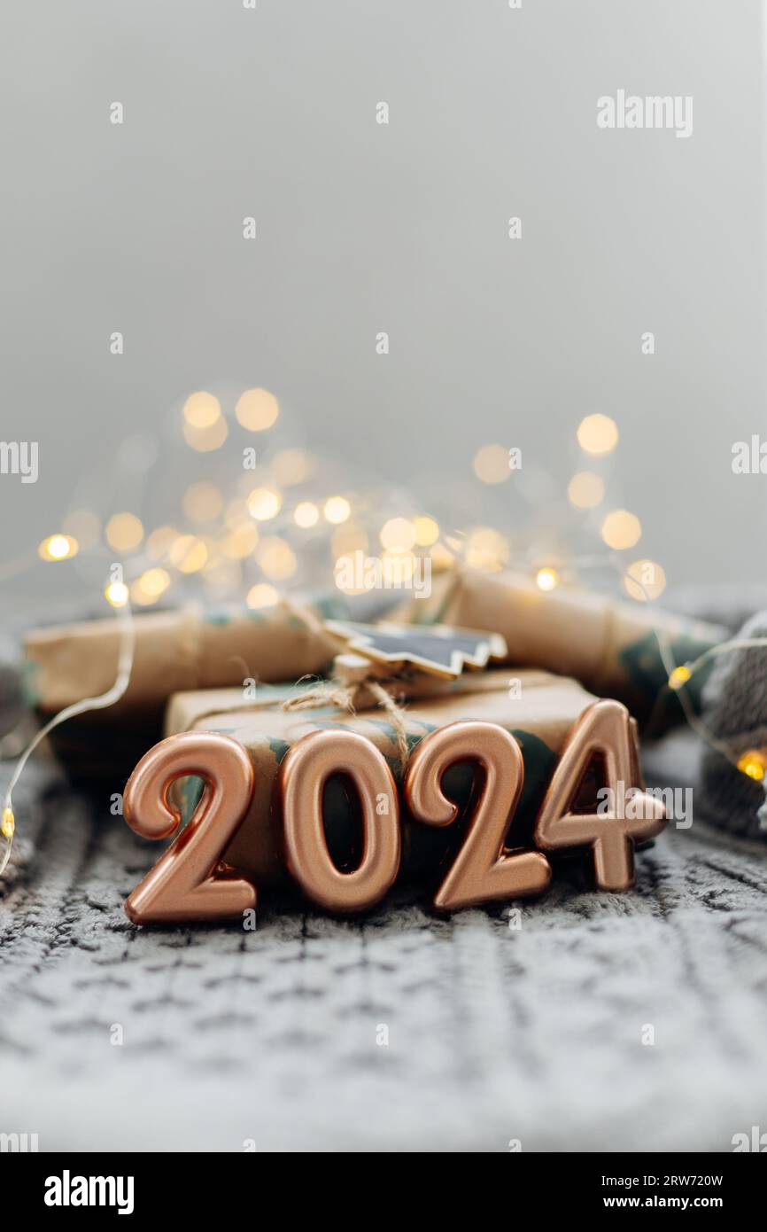 Christmas and New Year Greeting Card. Number 2024 on knitted background. Holiday lights bokeh ...