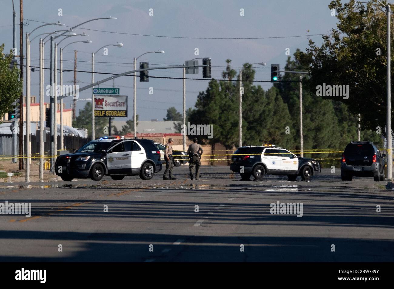 Police cars block off a street where a sheriff's deputy was shot while ...