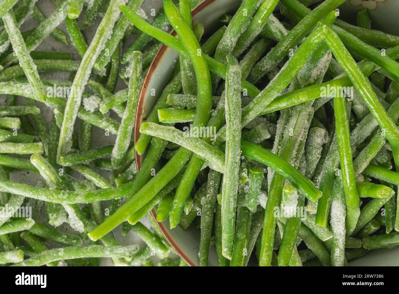 Frozen green beans, haricots verts, close up in a bowl, flat lay. Fresh ...