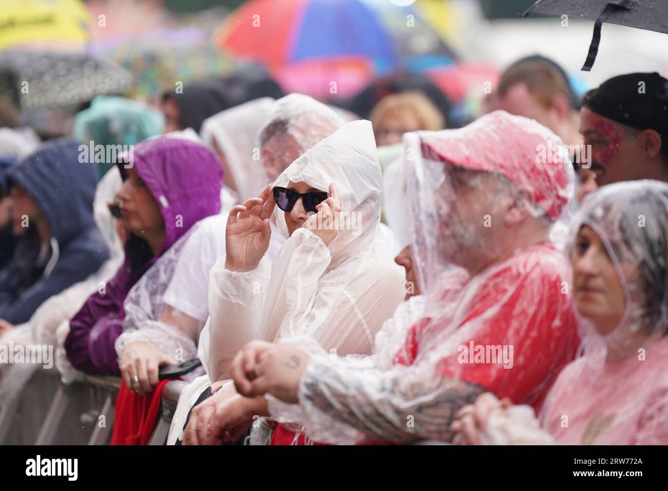 The crowd shelter from the rain as Rick Astley performs on stage at ...