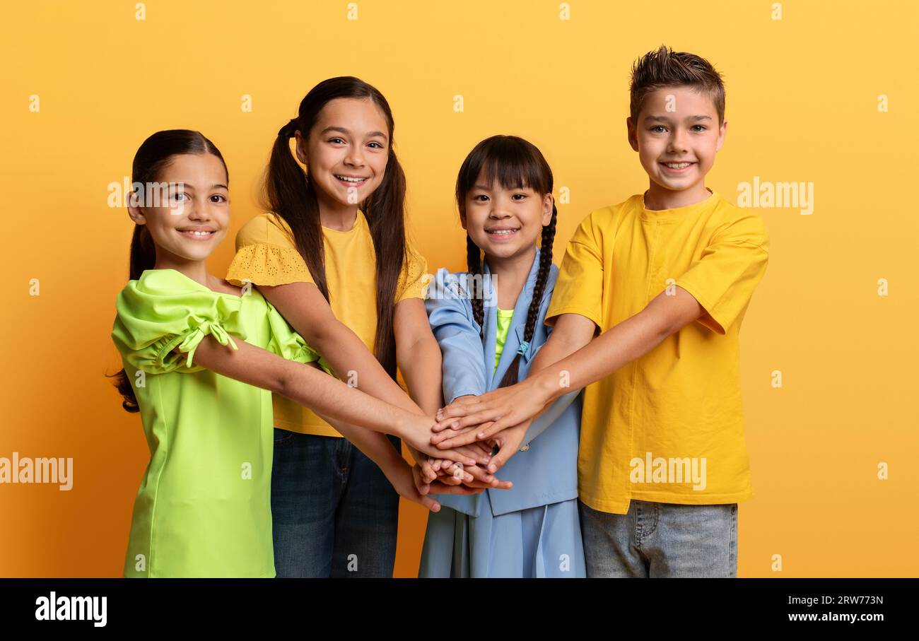 Positive diverse teenagers holding hands on top of each other Stock ...