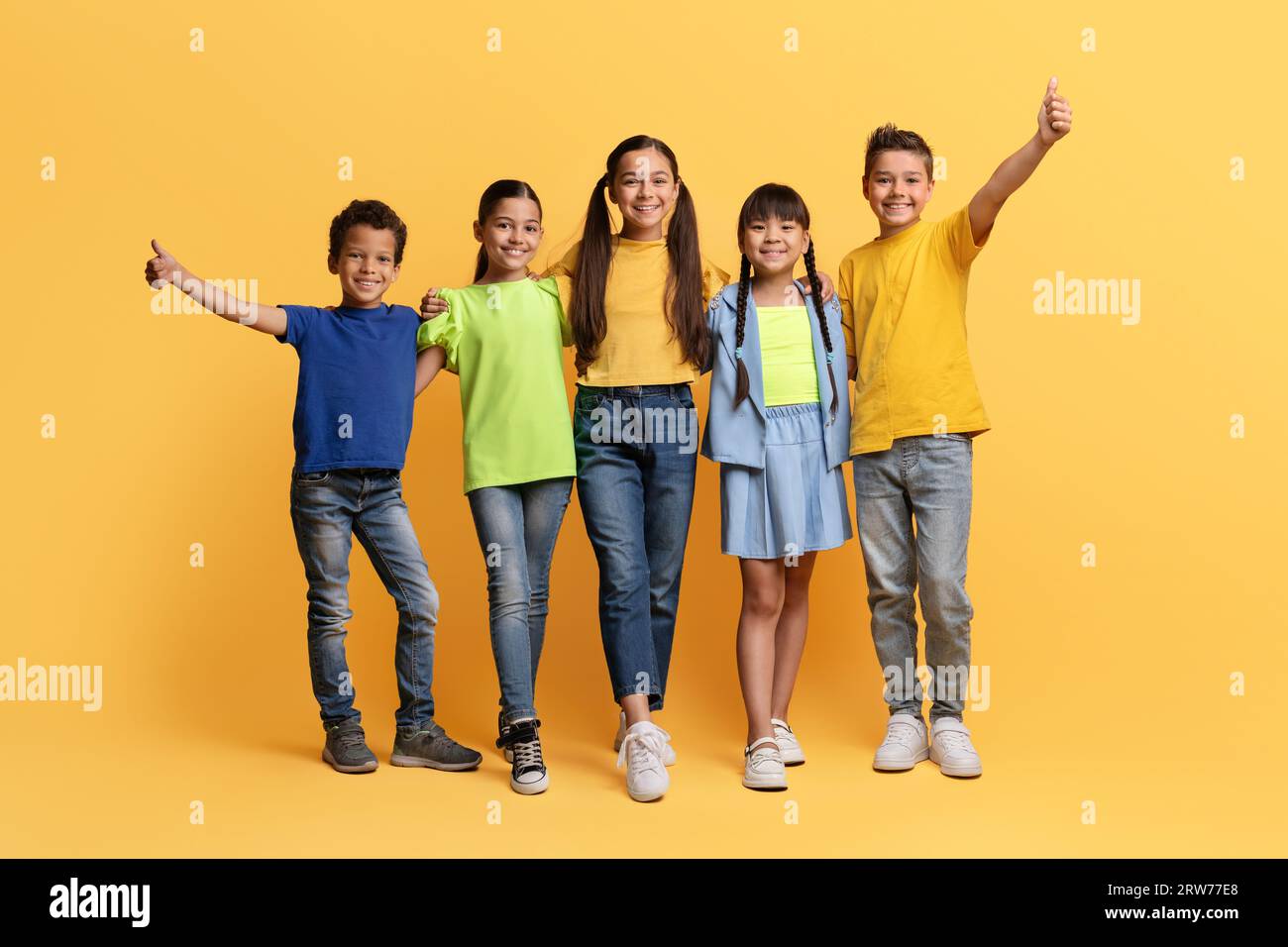 Cool diverse kids having fun on yellow background Stock Photo - Alamy