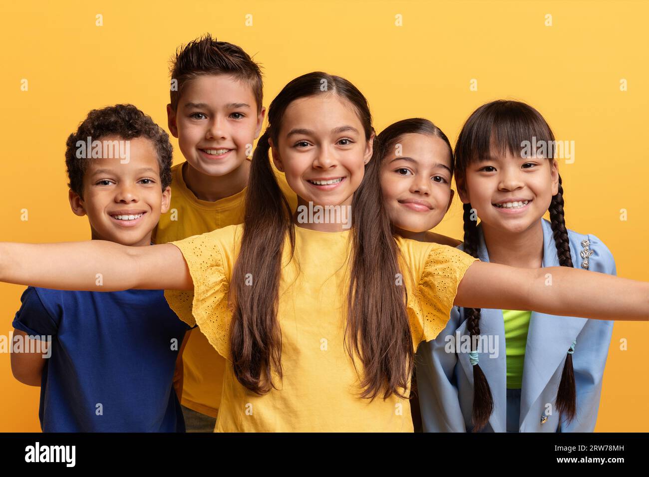 Cute happy multiracial kids taking photo on yellow background Stock ...