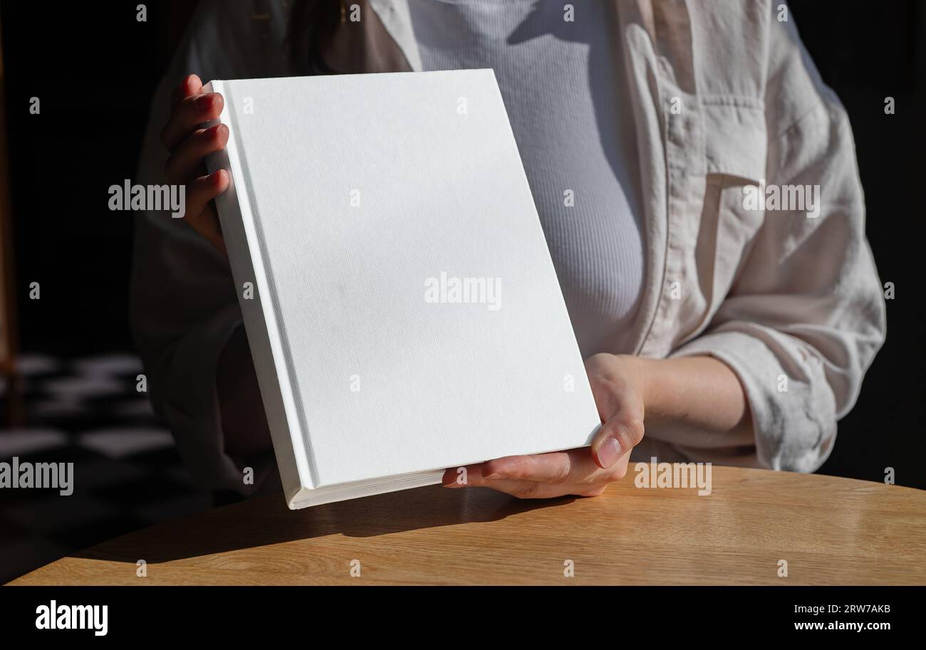 Showing, presenting book in hardcover mockup Stock Photo - Alamy