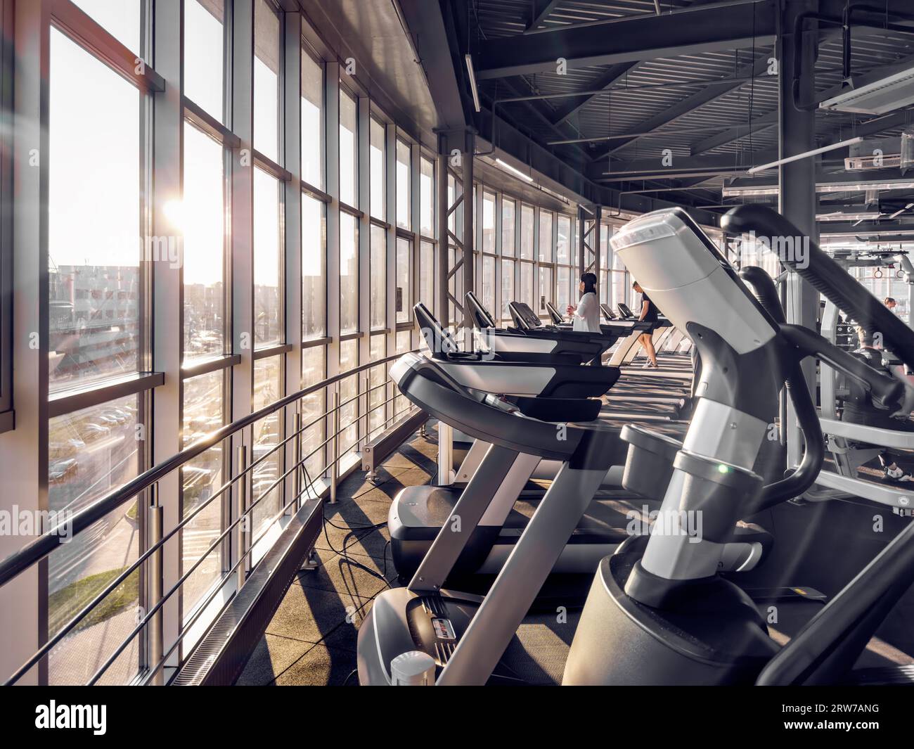 Sport gym with treadmills row and panoramic big window with sunny view ...