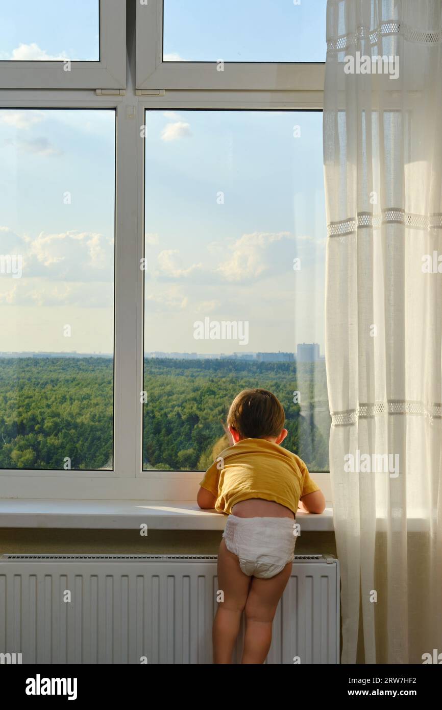 The child is alone by the window, lost in thought and risking their ...
