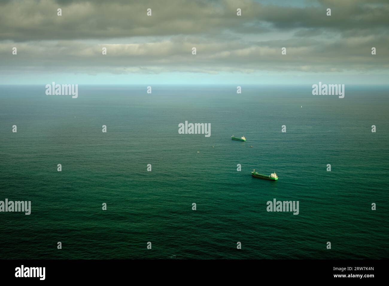 horizontal panorama of two large cargo ships waiting to enter the port ...