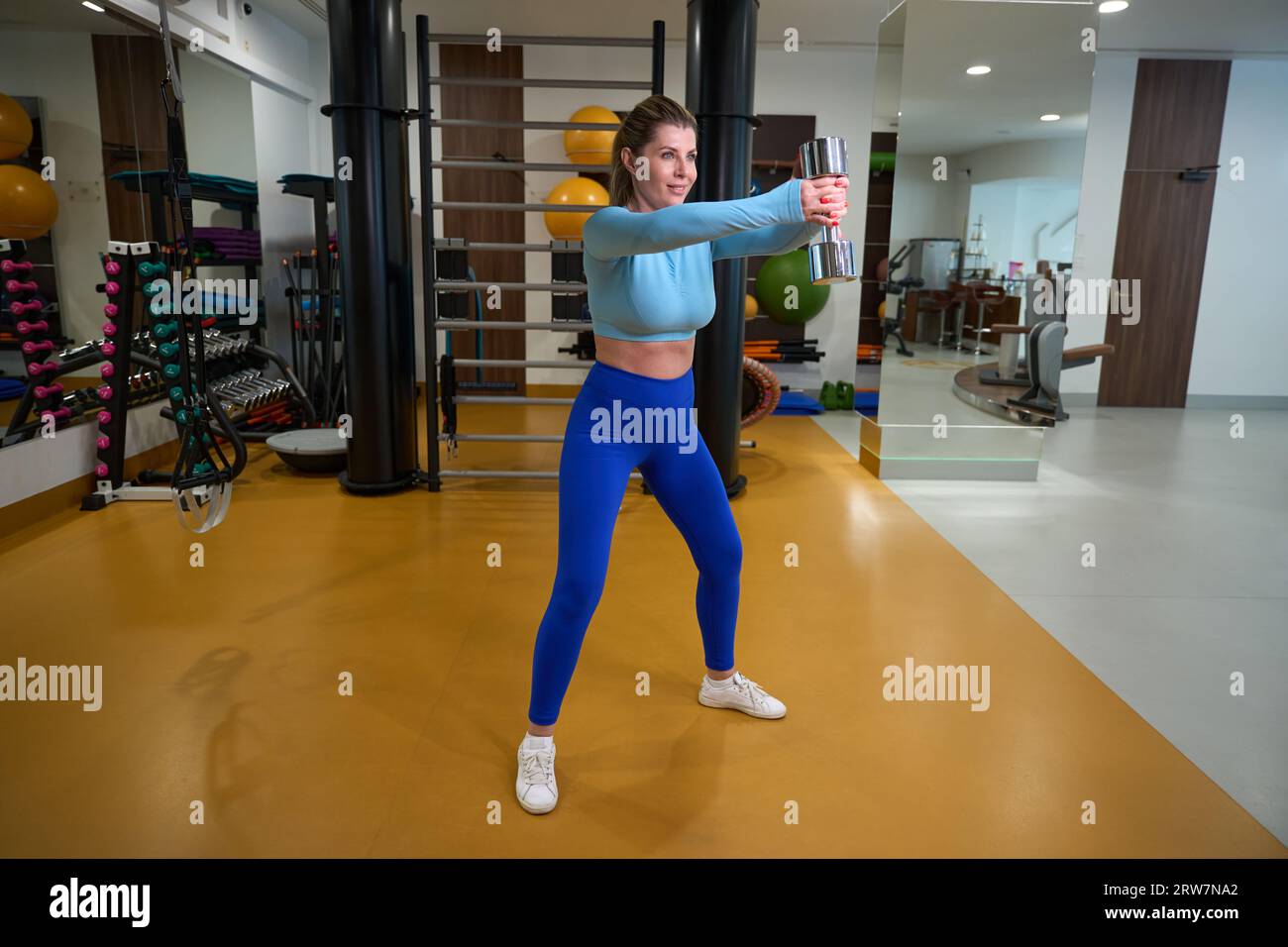 Athletic woman doing sports exercises using dumbbell, pumping-up ...