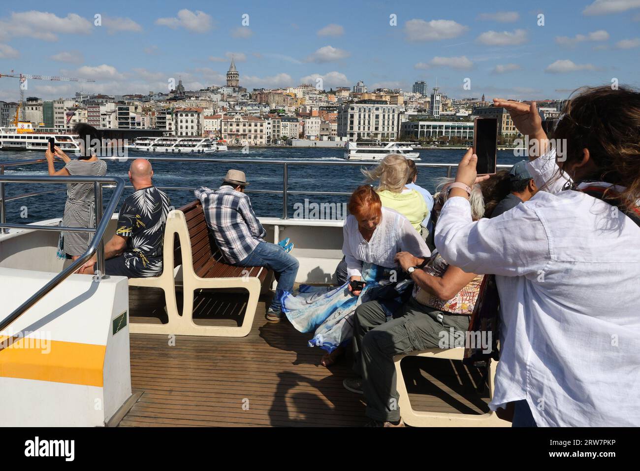 Tourists taking photographs and filming of Istanbul from a ferry ...