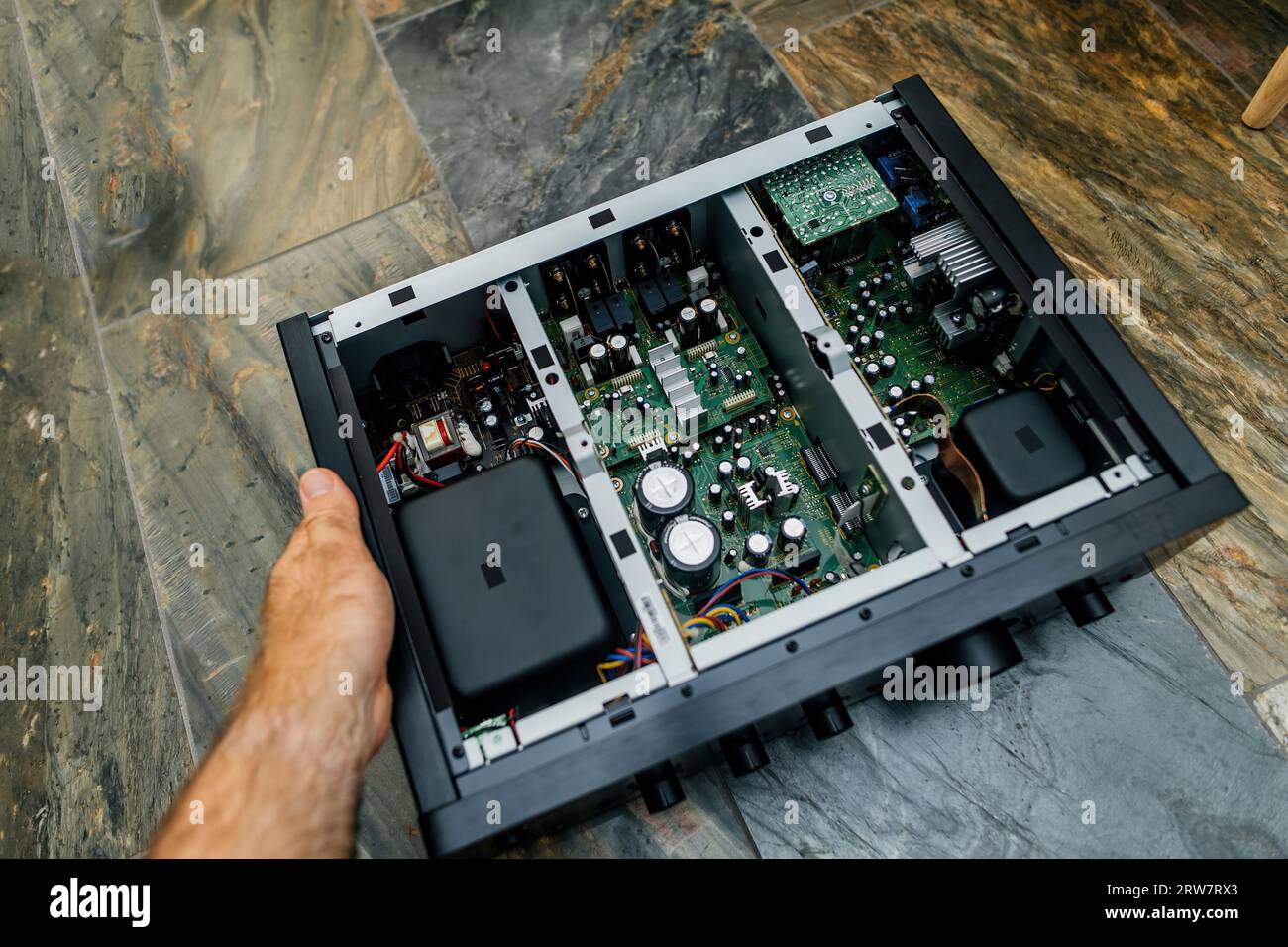 Overhead view of a male hand examining the internal components while ...