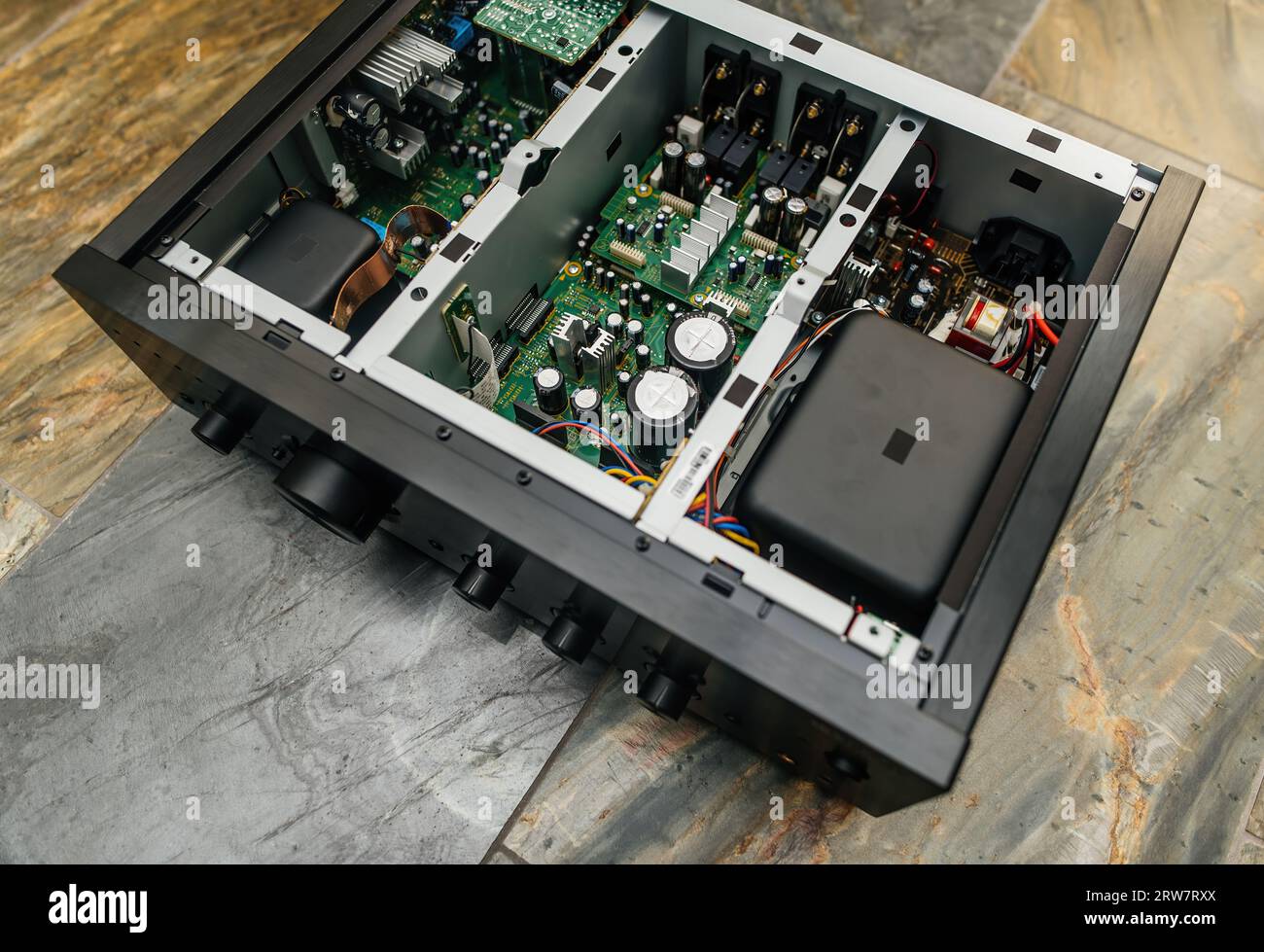 A detailed close-up of an open metallic lid exposes the components of a ...