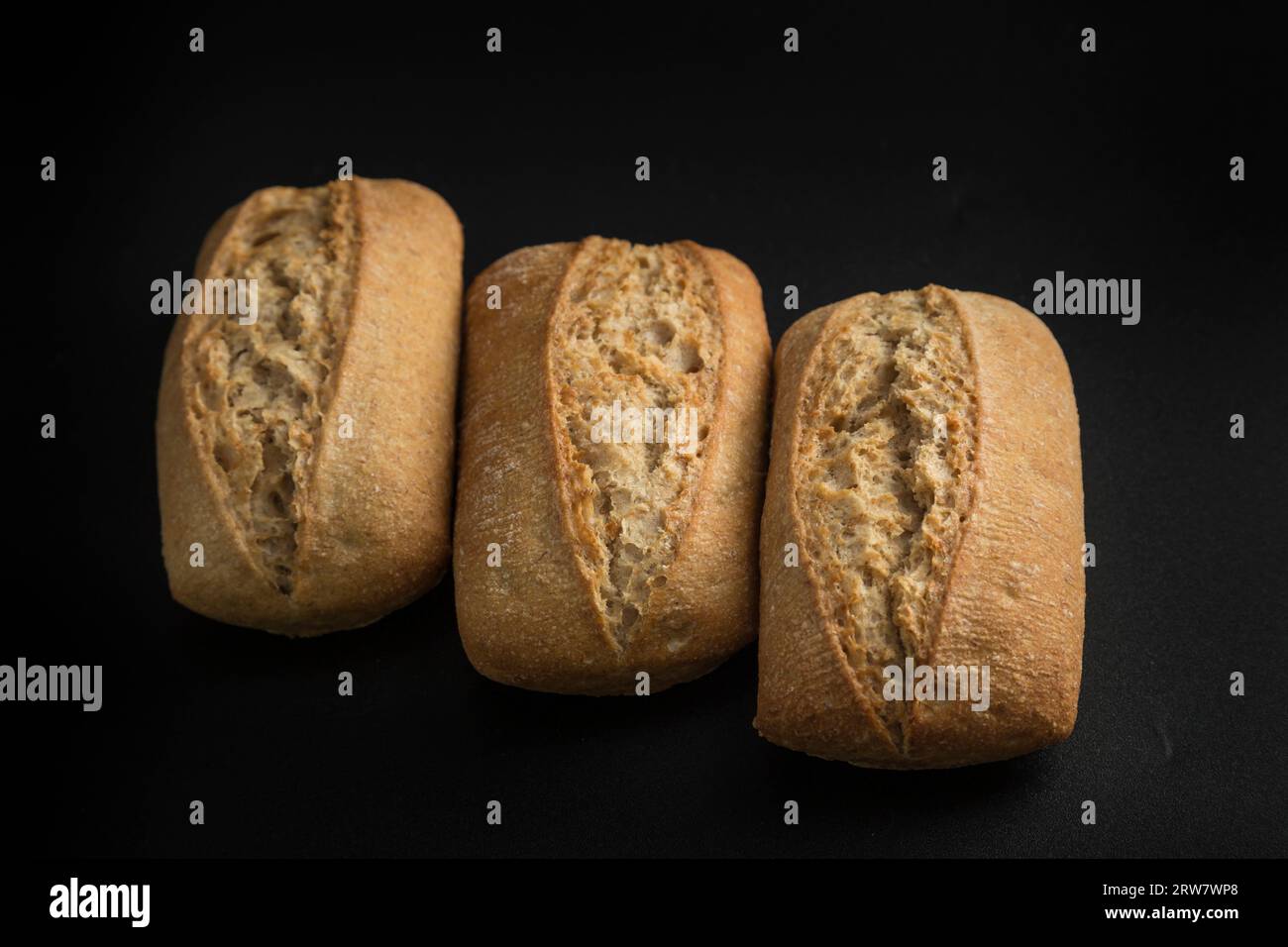 still life with three buns placed together on a black background Stock ...