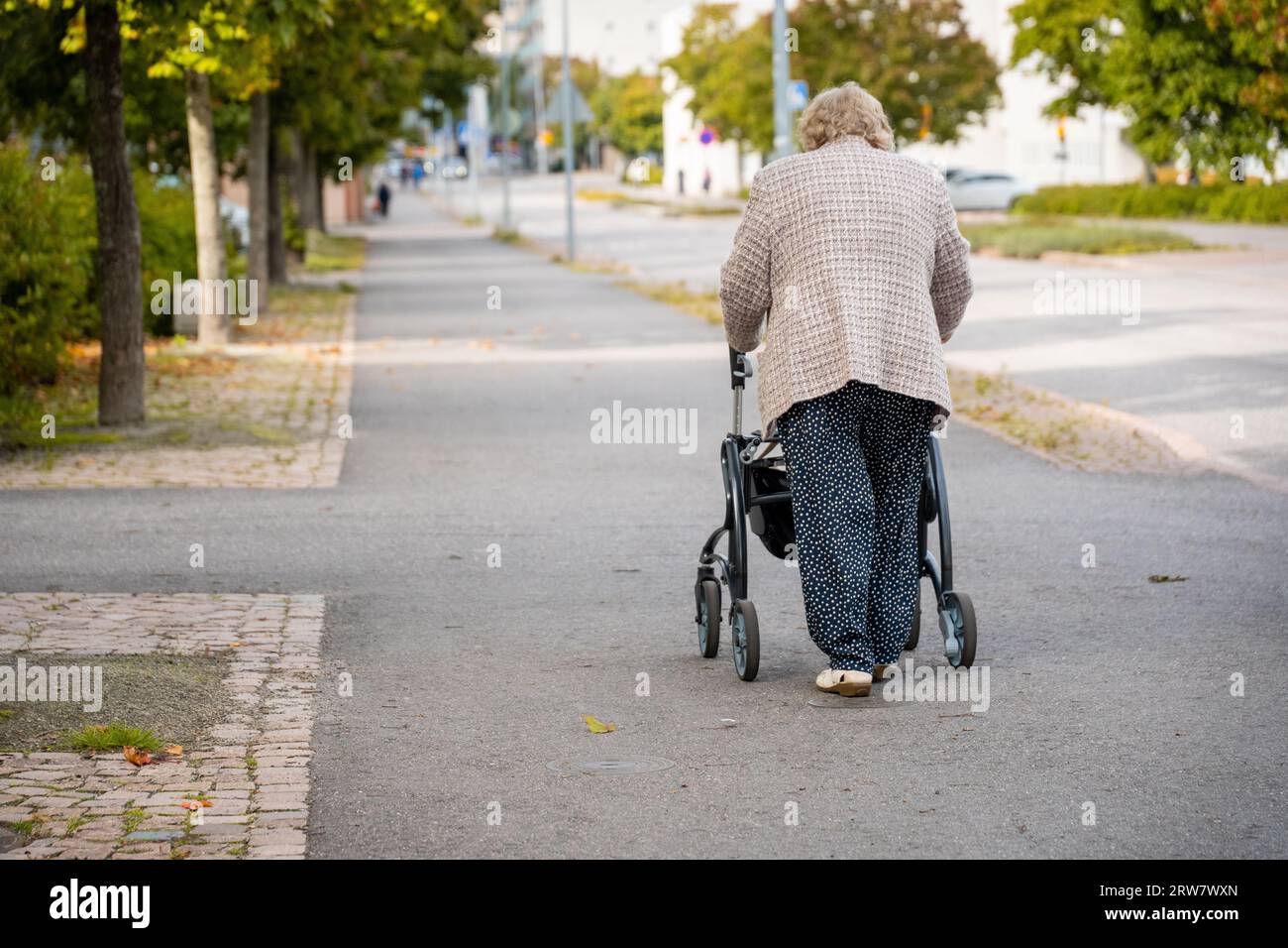Old woman walking on street with rollator walker Stock Photo - Alamy