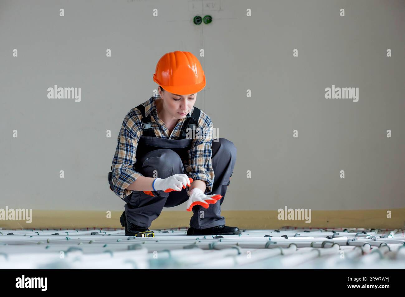 Woman worker is installing underfloor heating system. Warm floor ...