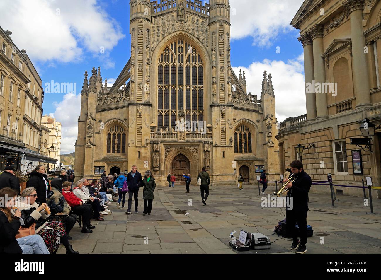 Trumpet player entertaining a lunchtime audience, outside Bath Abbey ...