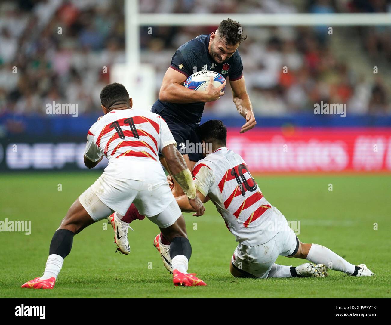 England's Jonny May (centre) tackled by Japan's Jone Naikabula and ...