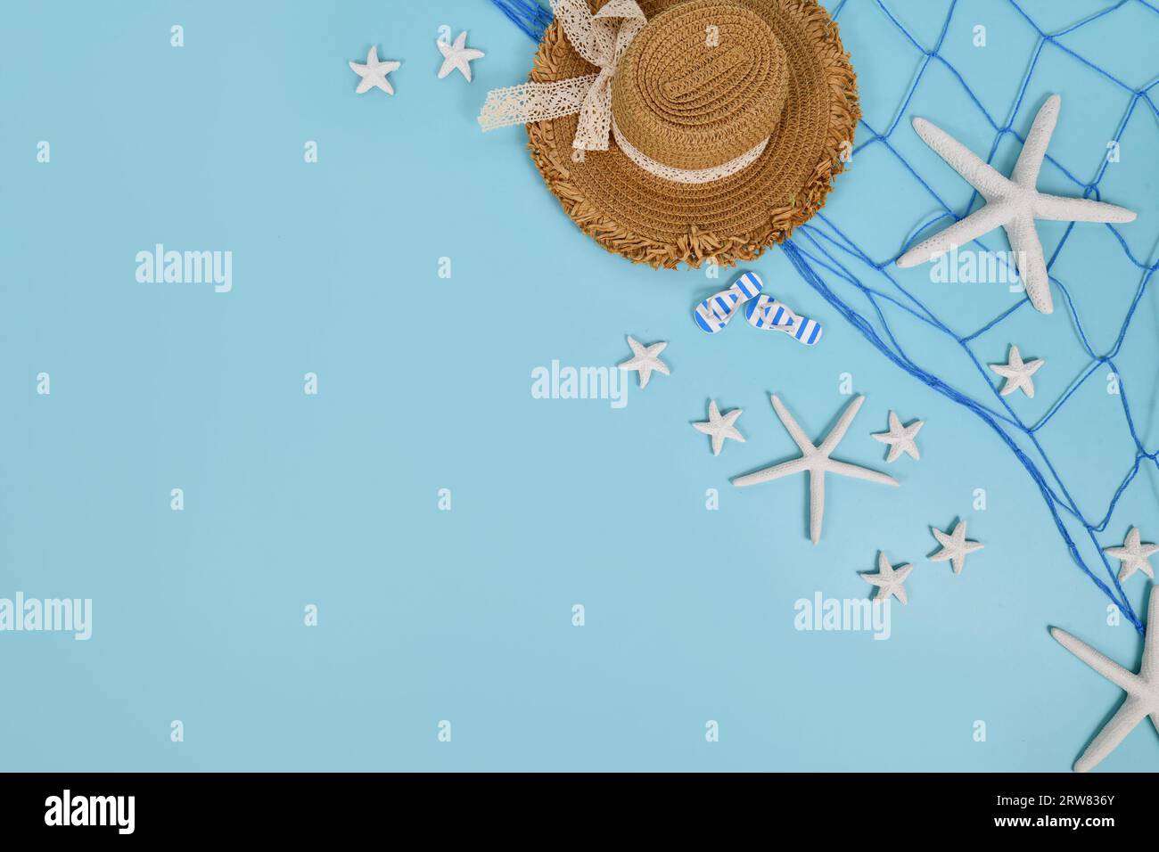 Simple summer banner with straw hat and fishing net and white starfish ...