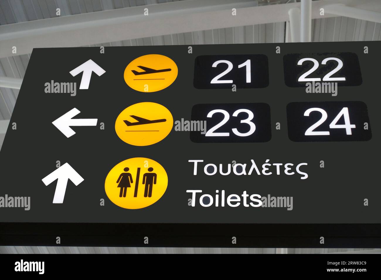 Sign to departure gates and toilets at the airport with Greek and ...