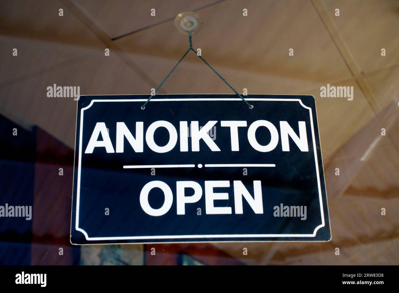 Open sign in Greek and English languages hanging on the door of a shop ...