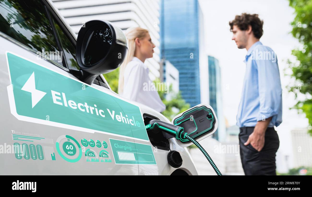 Business people waiting after recharge electric car from charging ...