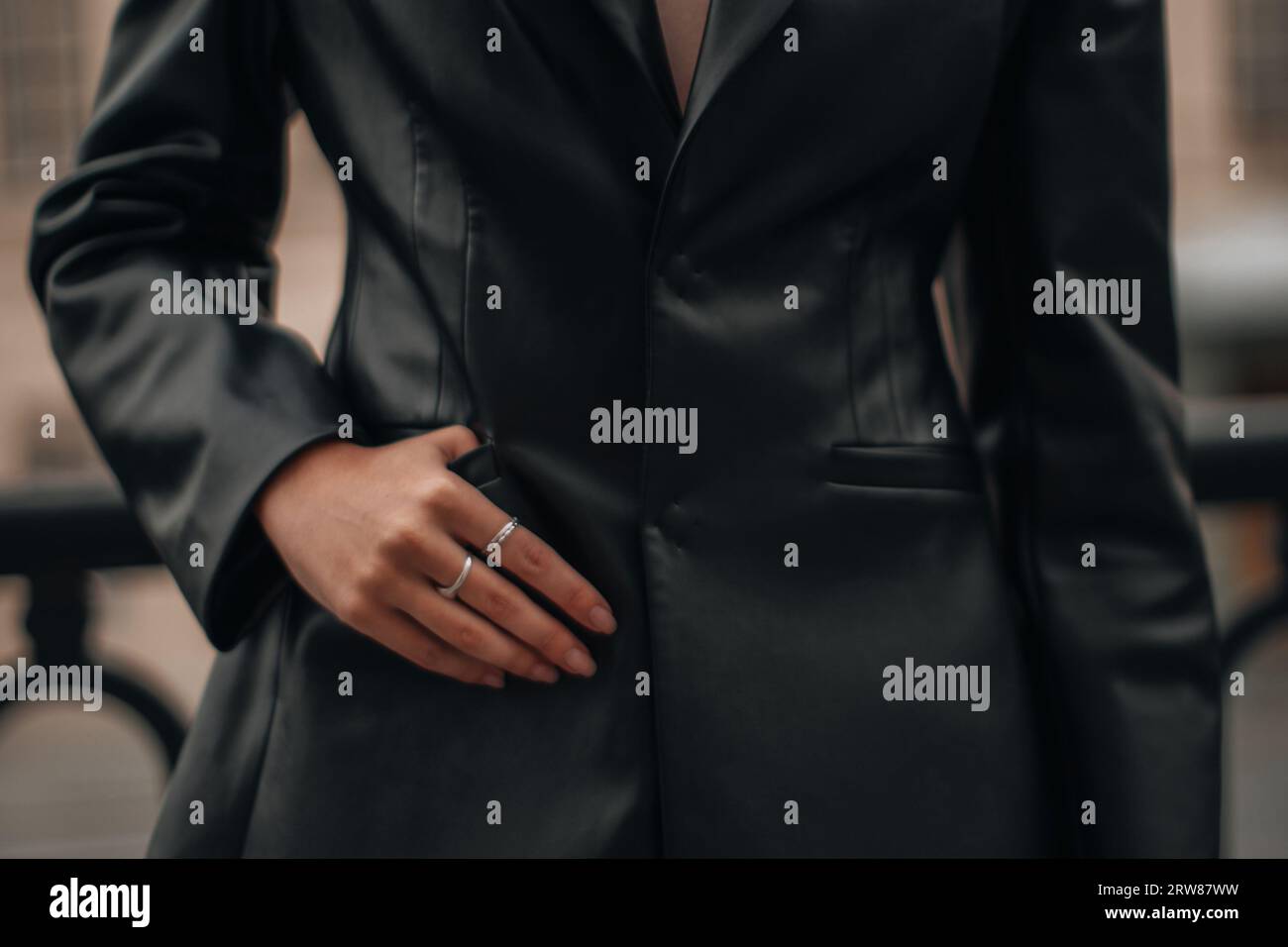 Fashion details of a black leather jacket with pockets and female hands ...