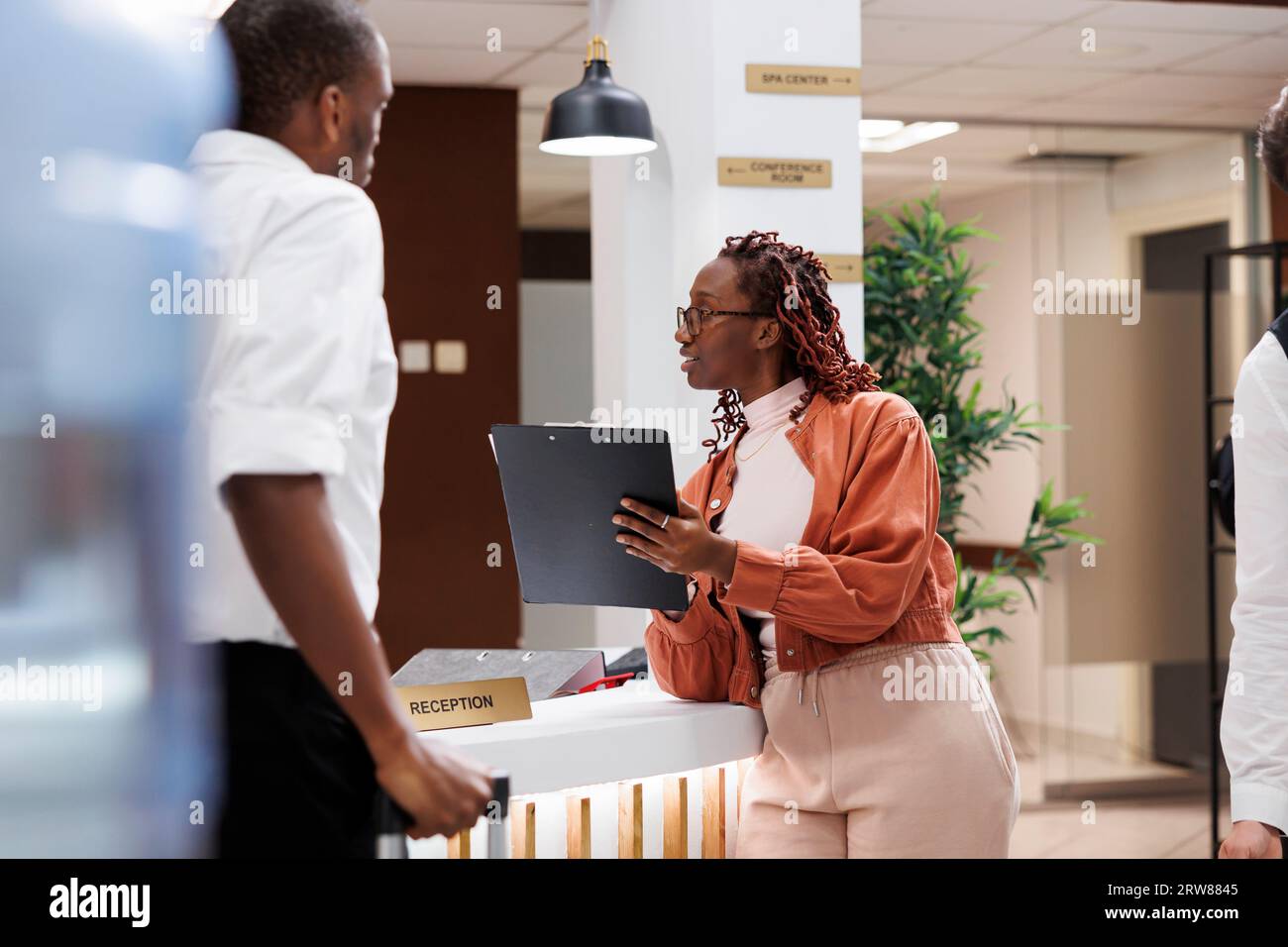 African american woman doing check in with registration files, hotel ...