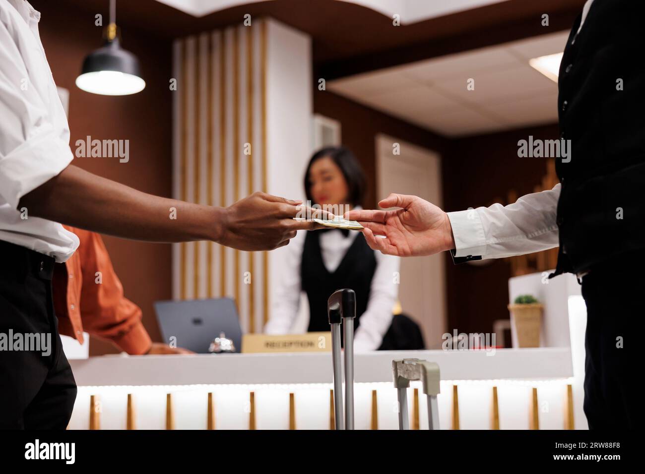 Guest giving cash to bellboy in lobby, paying money for luxury service ...