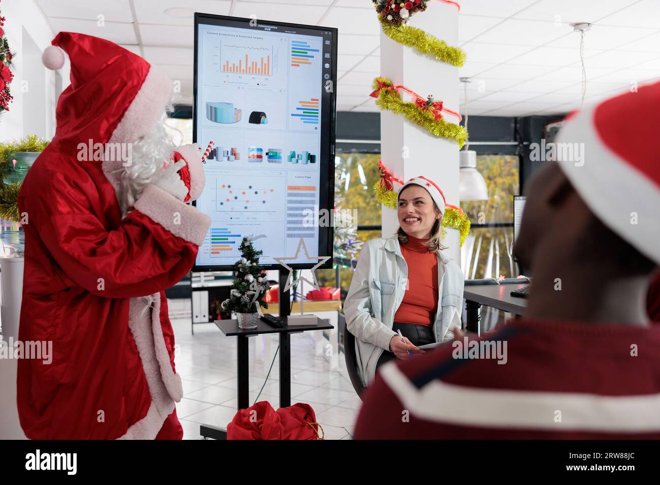 Employee dressed as Santa Claus playing charades with colleagues during ...