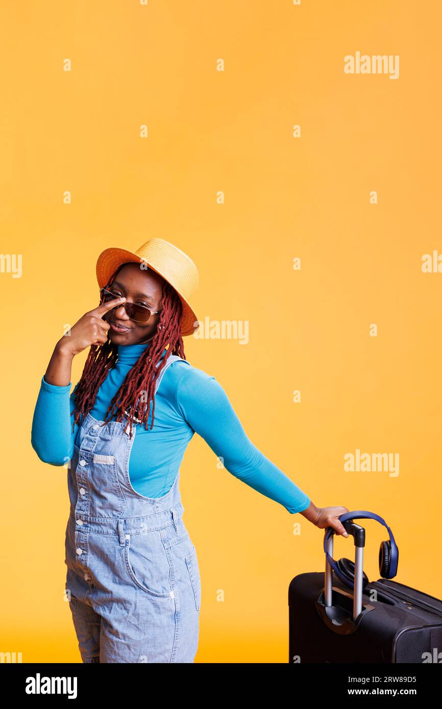 African american woman with sunglasses leaving on holiday with hat and ...