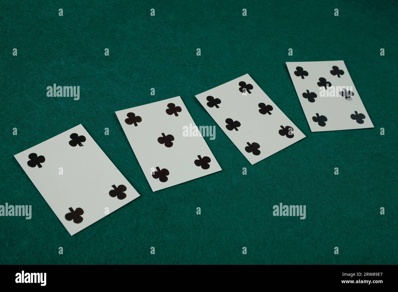 Old west era playing card on green gambling table. 4,5,6 and 7 of clubs ...