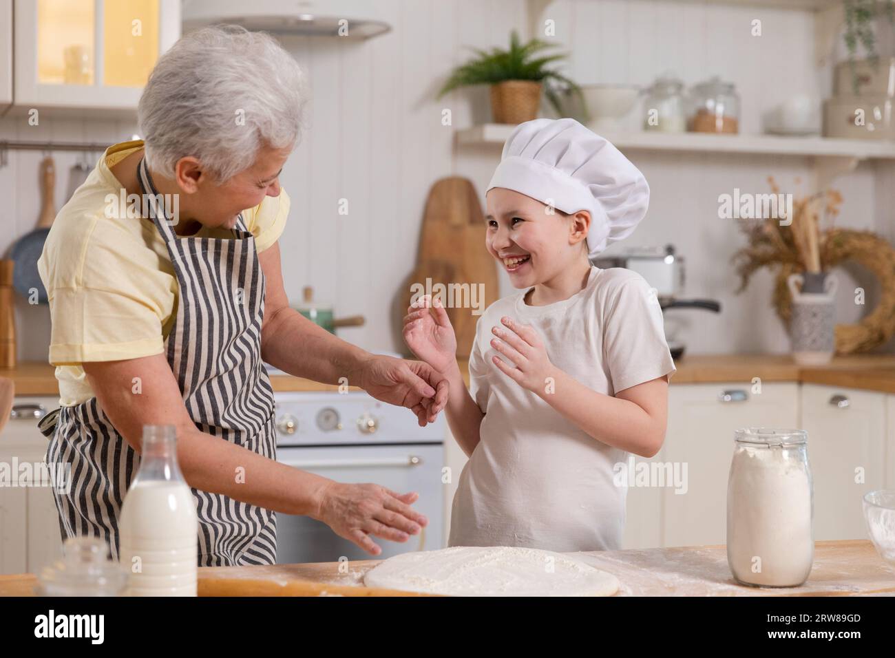 Happy family in kitchen. Grandmother and granddaughter child cook in ...