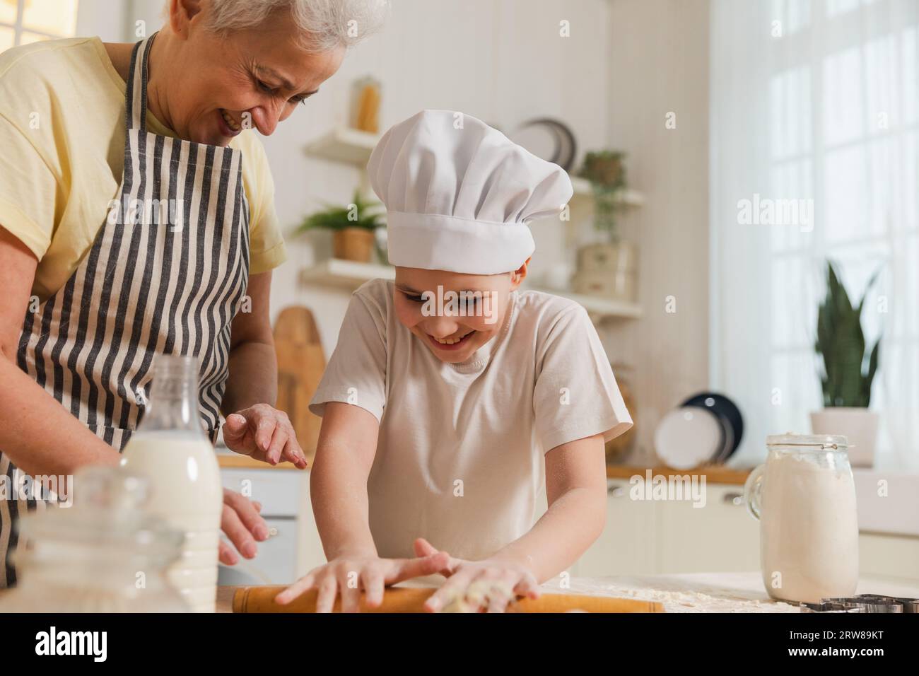 Happy family in kitchen. Grandmother and granddaughter child cook in ...