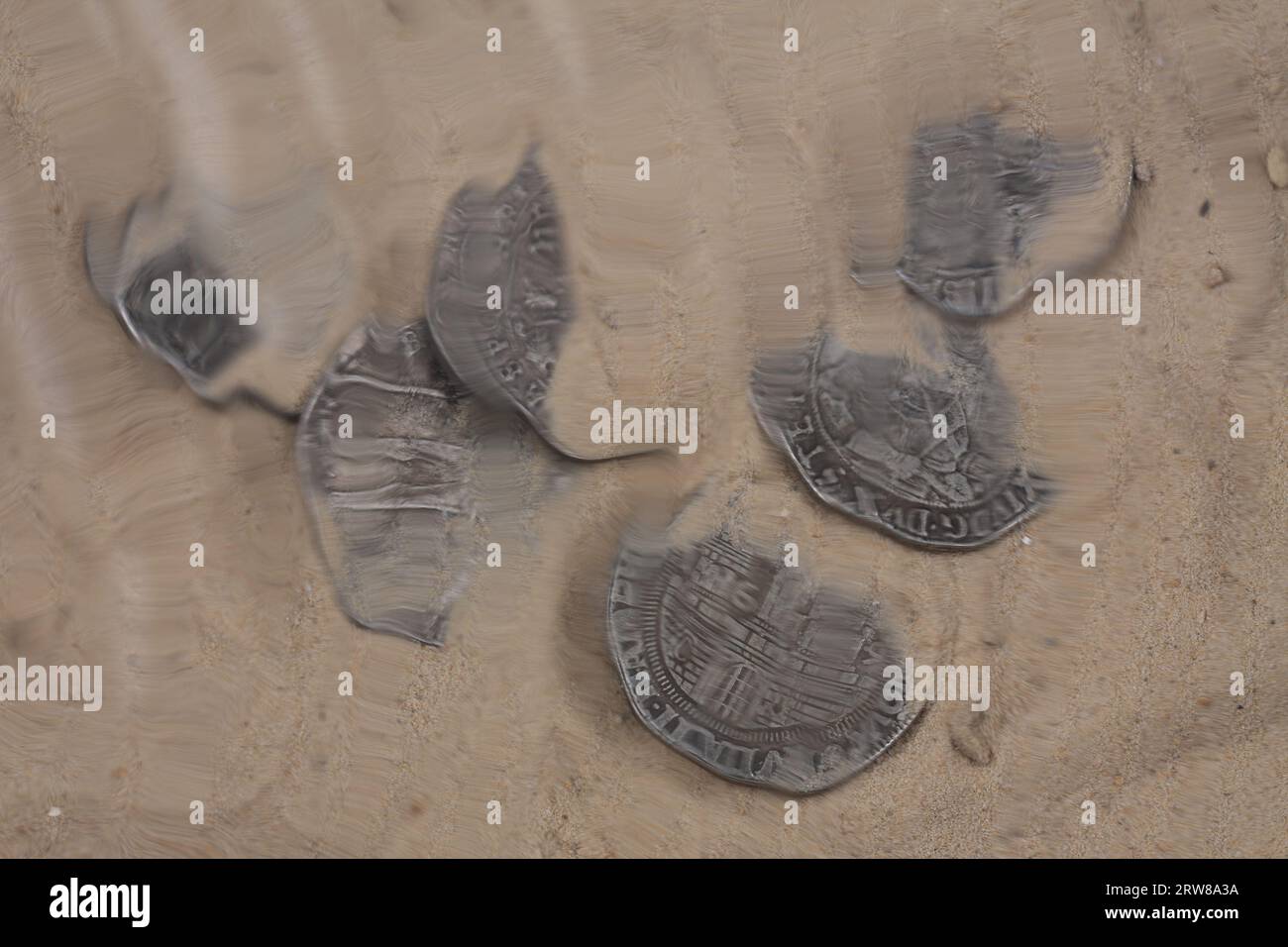 coin in sand under the water background Stock Photo - Alamy