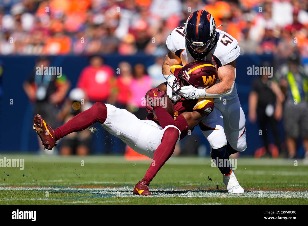 Washington Commanders wide receiver Terry McLaurin, bottom, is stopped by Denver Broncos ...