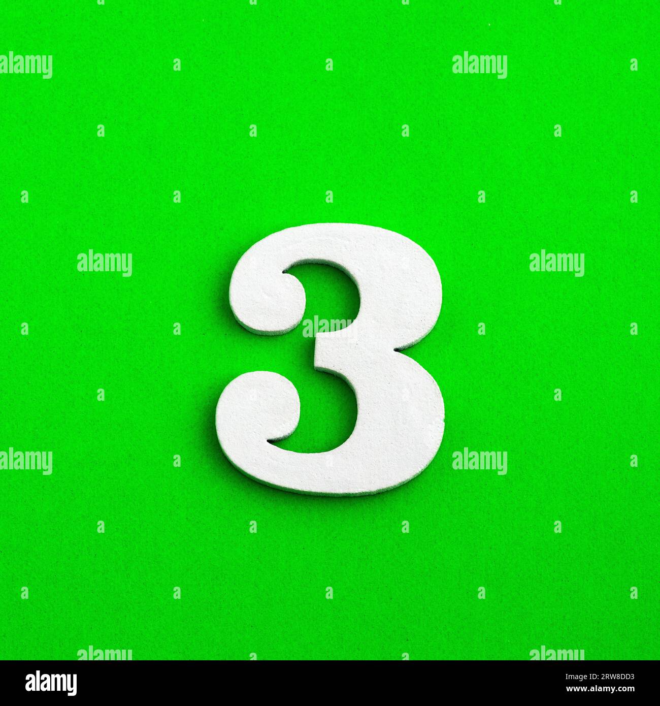Number three - white number in wood on green background Stock Photo - Alamy