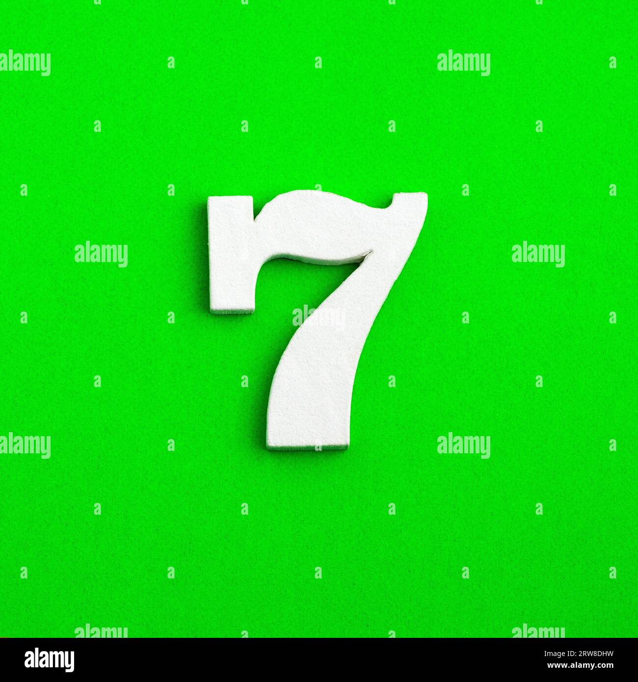 Number seven - white number in wood on green background Stock Photo - Alamy
