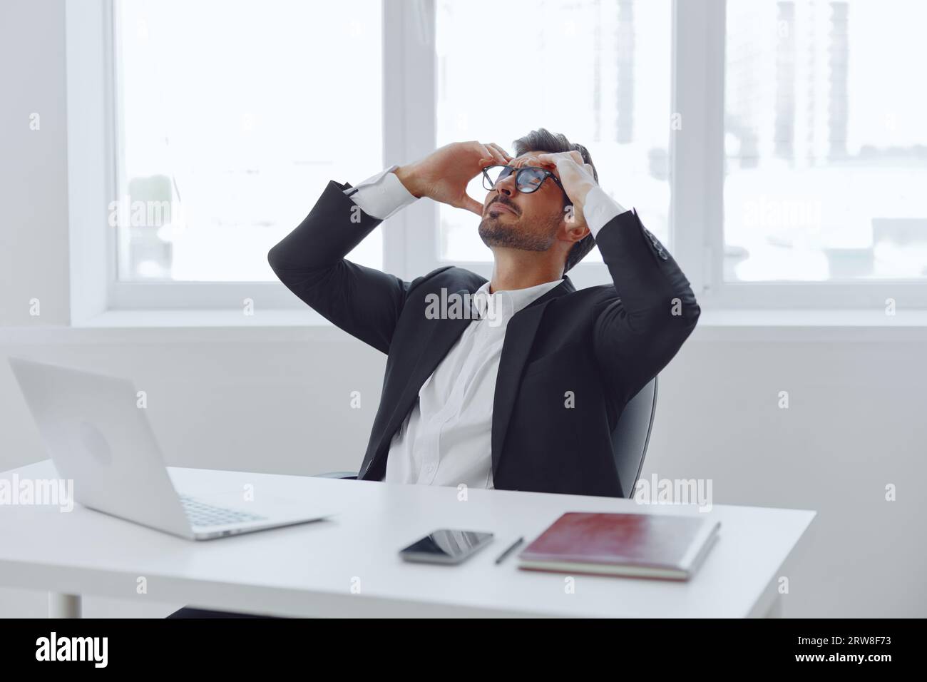 Man tired table desk glasses executive office working laptop indoors ...