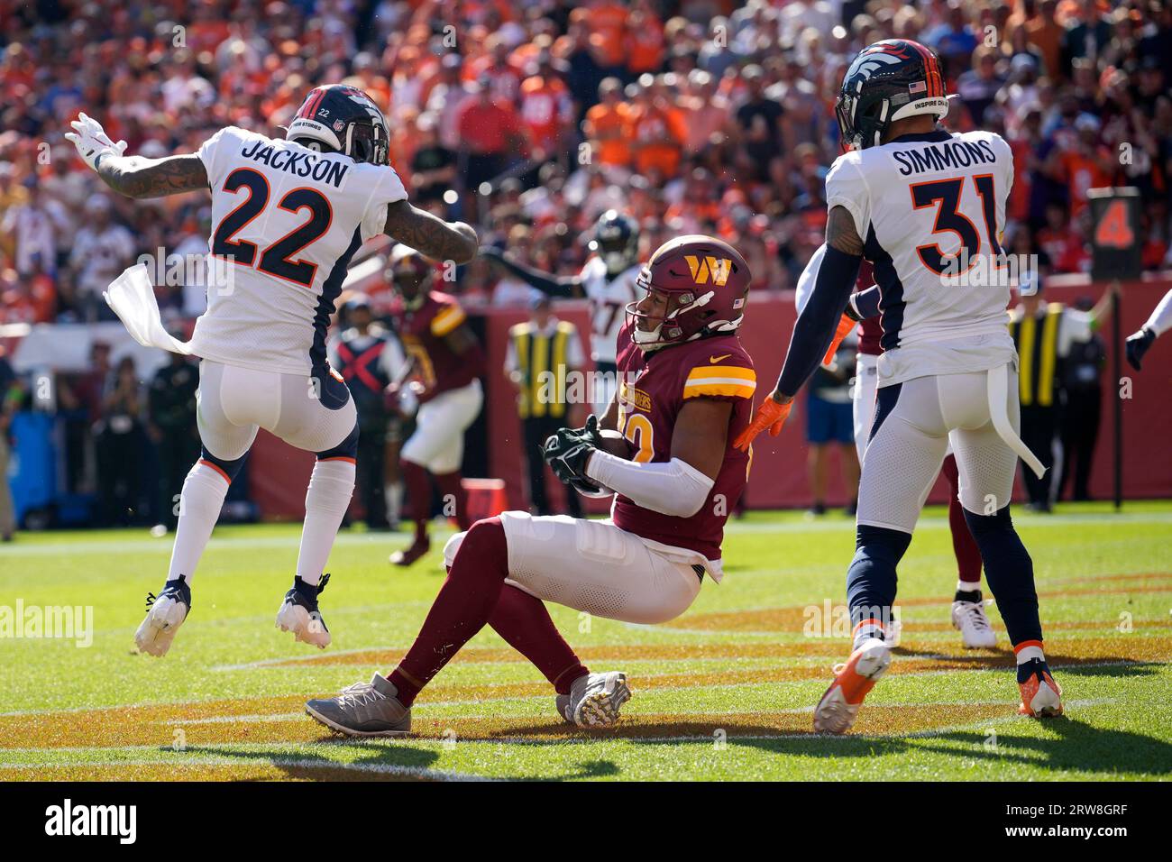Washington Commanders tight end Logan Thomas, center, catches a touchdown pass as he is hit by ...