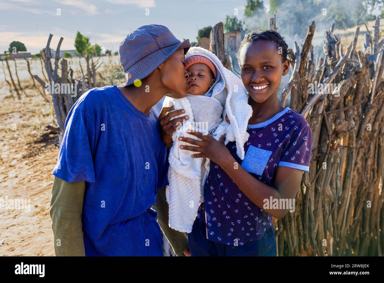 african baby held and kissed by his bigger sisters in front of the ...