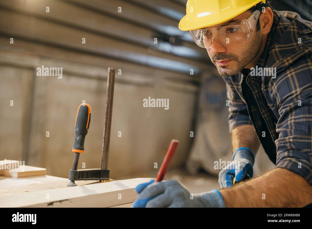 Carpenter man wear gloves during working using tape measure and pencil ...