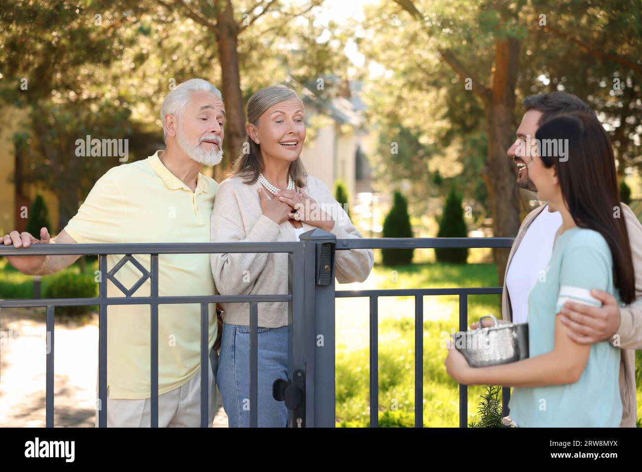 Friendly relationship with neighbours. Young family talking to elderly ...