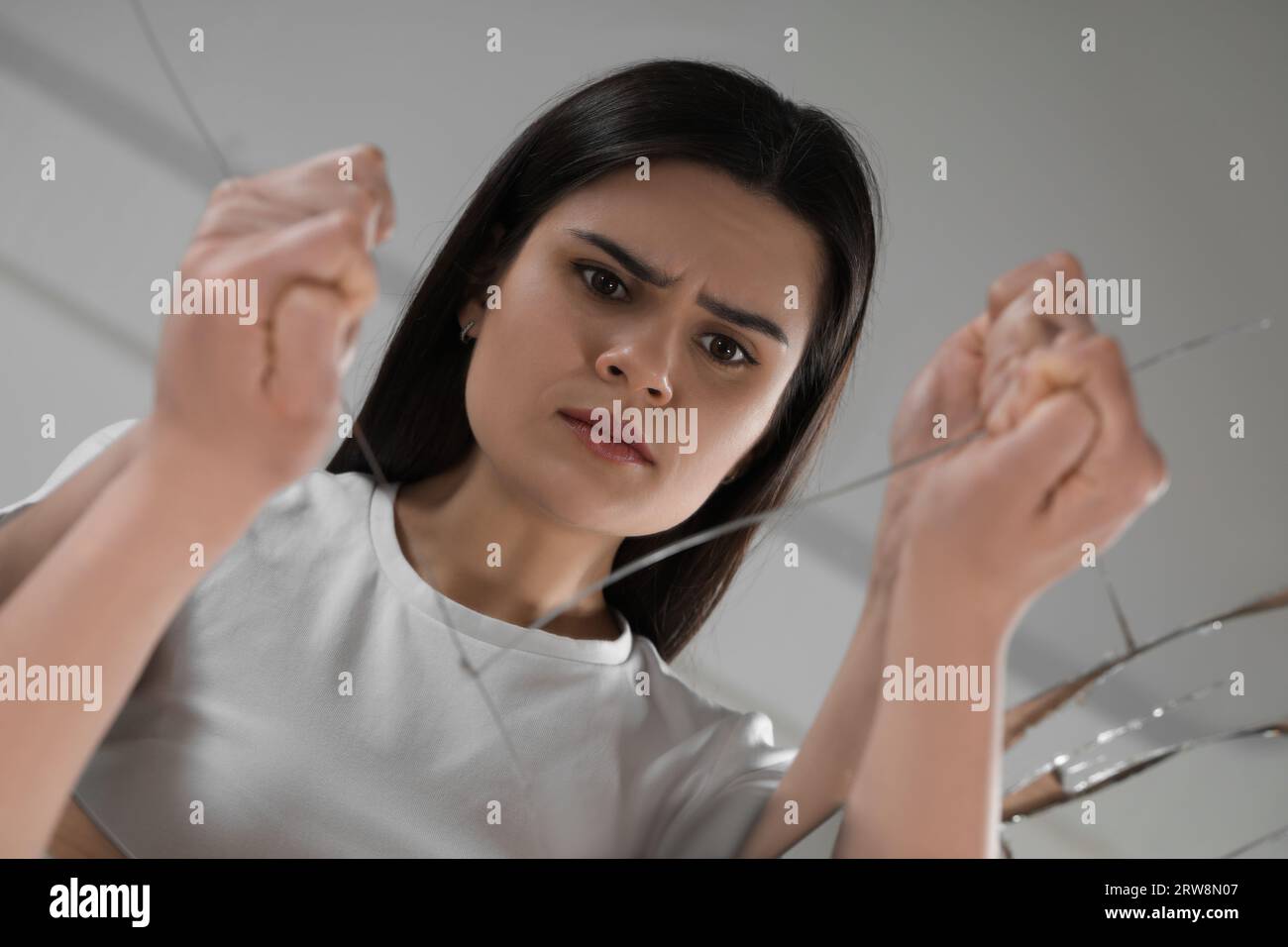 Sad woman looking at herself in broken mirror, top view. Mental ...