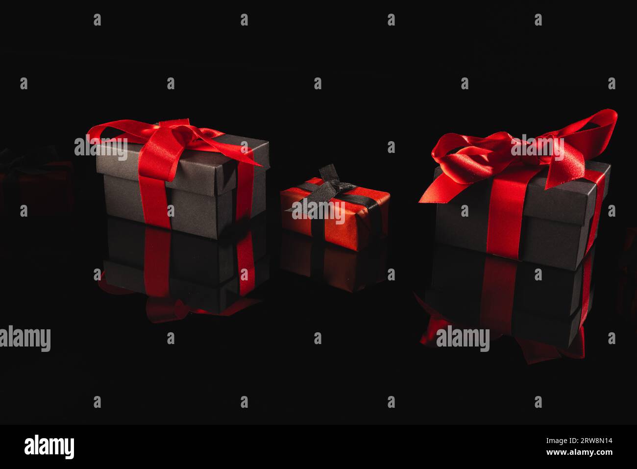 Black and red gift boxes with ribbon and copy space over black ...