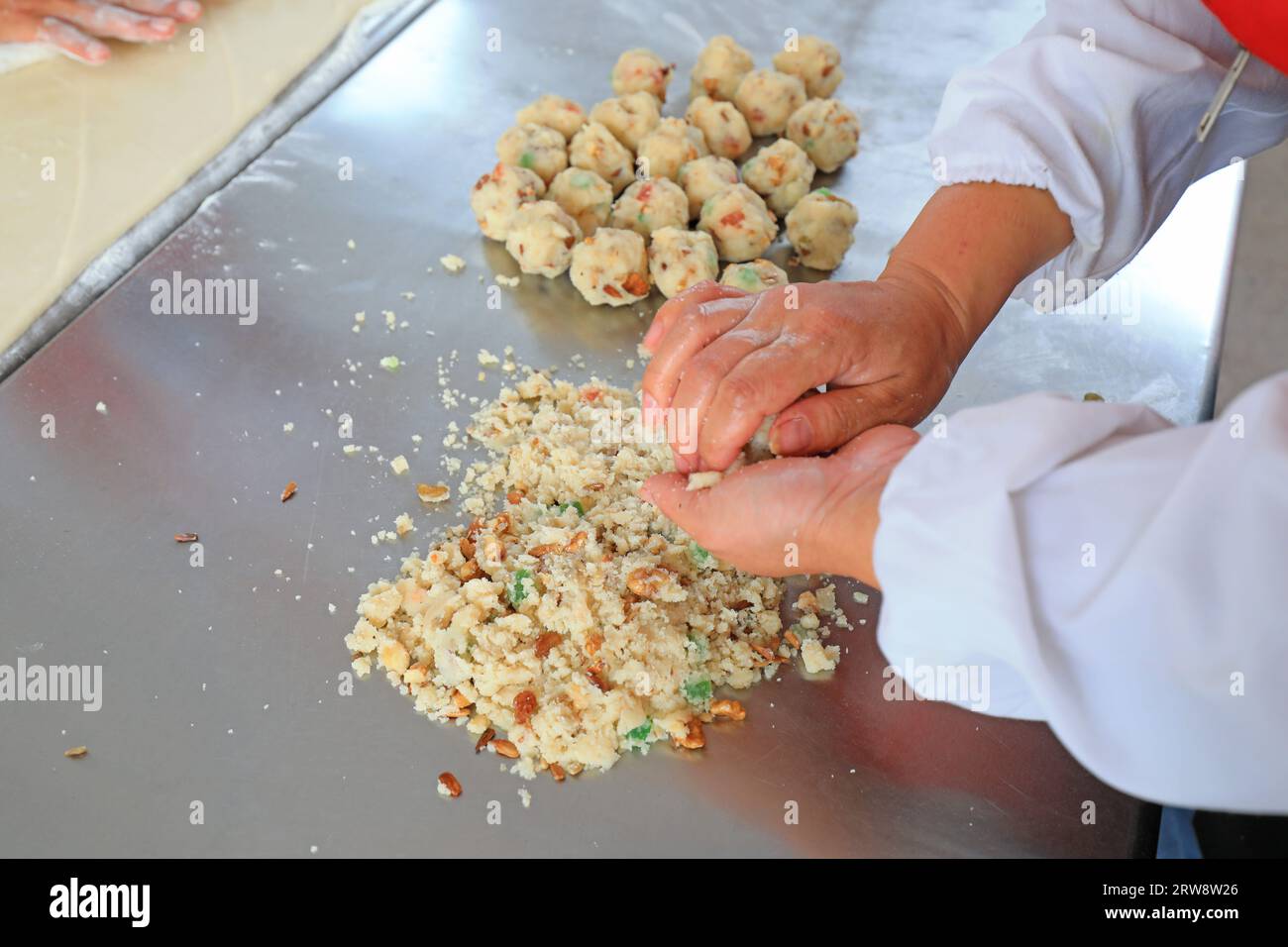 Workers are making moon cake stuffing by hand in a food processing ...