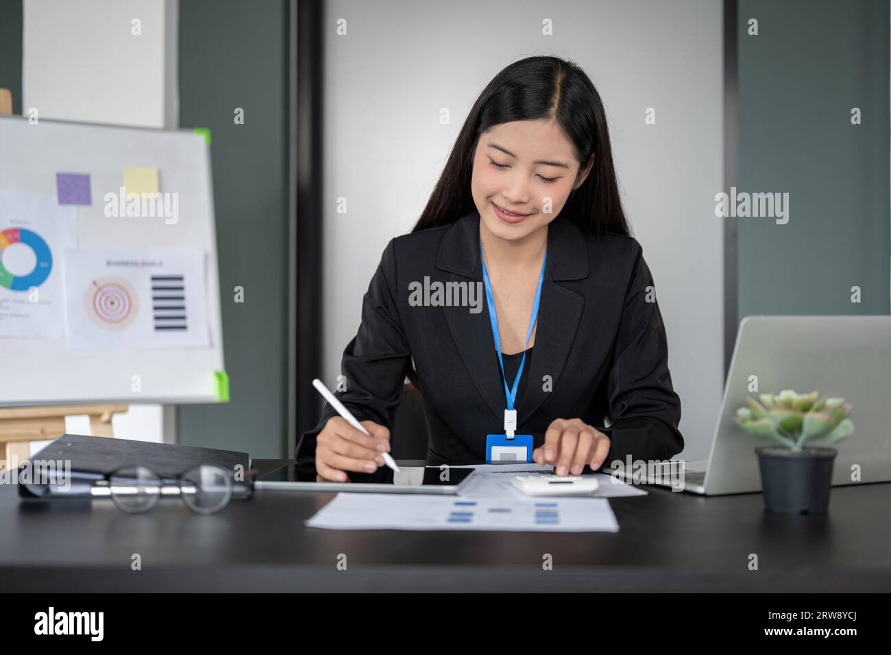 A beautiful and happy millennial Asian businesswoman or female auditor ...