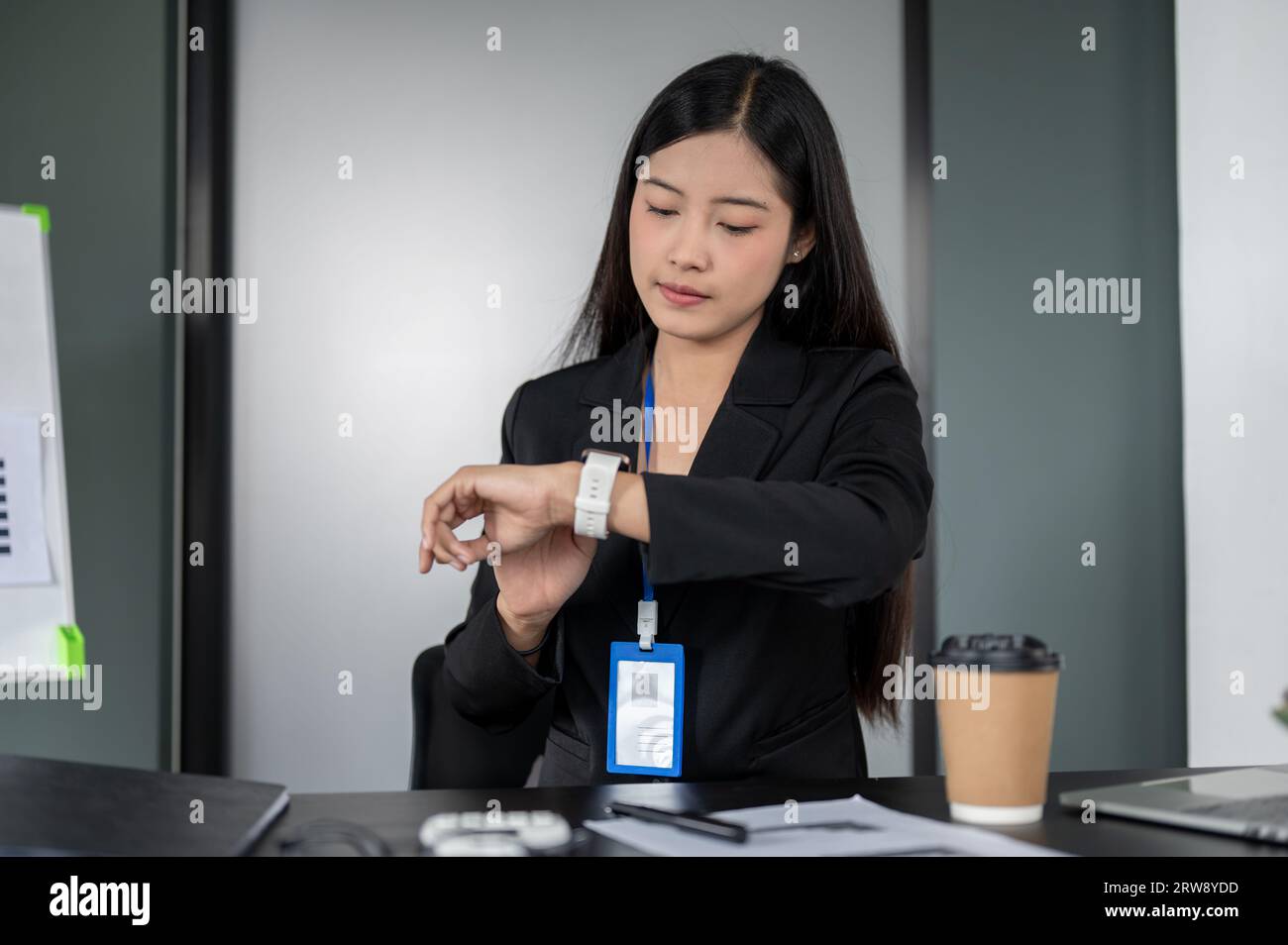 Woman checking clock office hi-res stock photography and images - Alamy